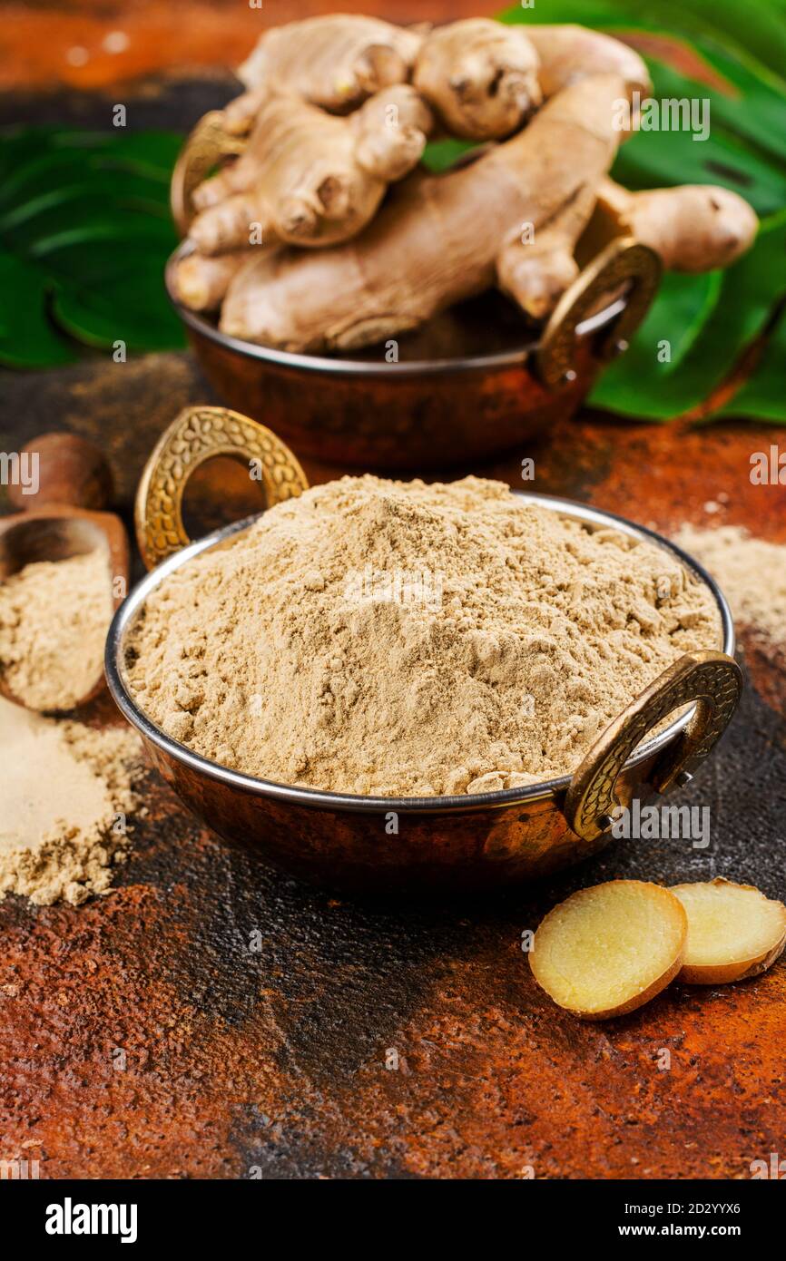 Ginger powder and fresh root Stock Photo - Alamy