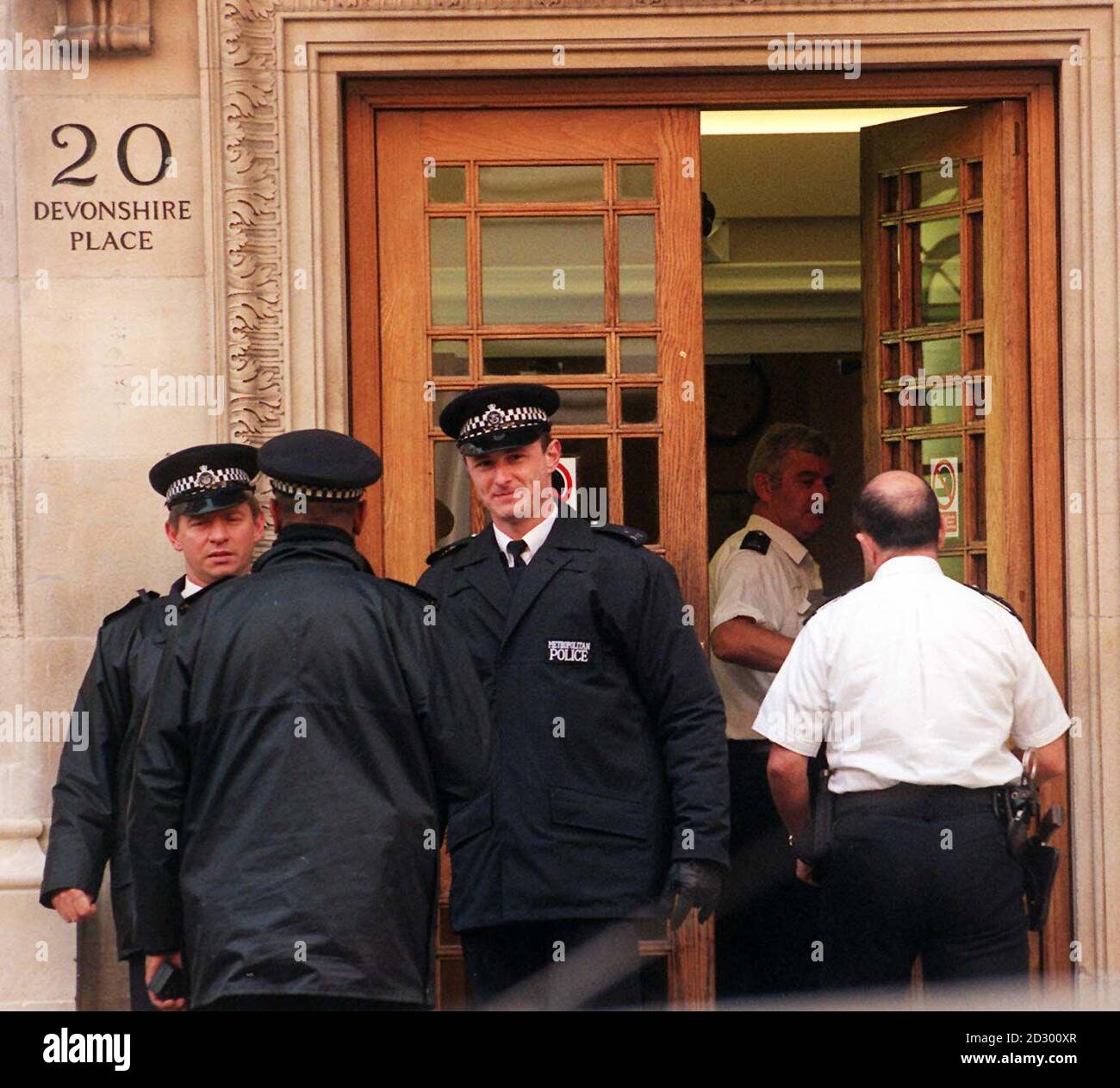 An armed police officer passing through the doors of the clinic in ...