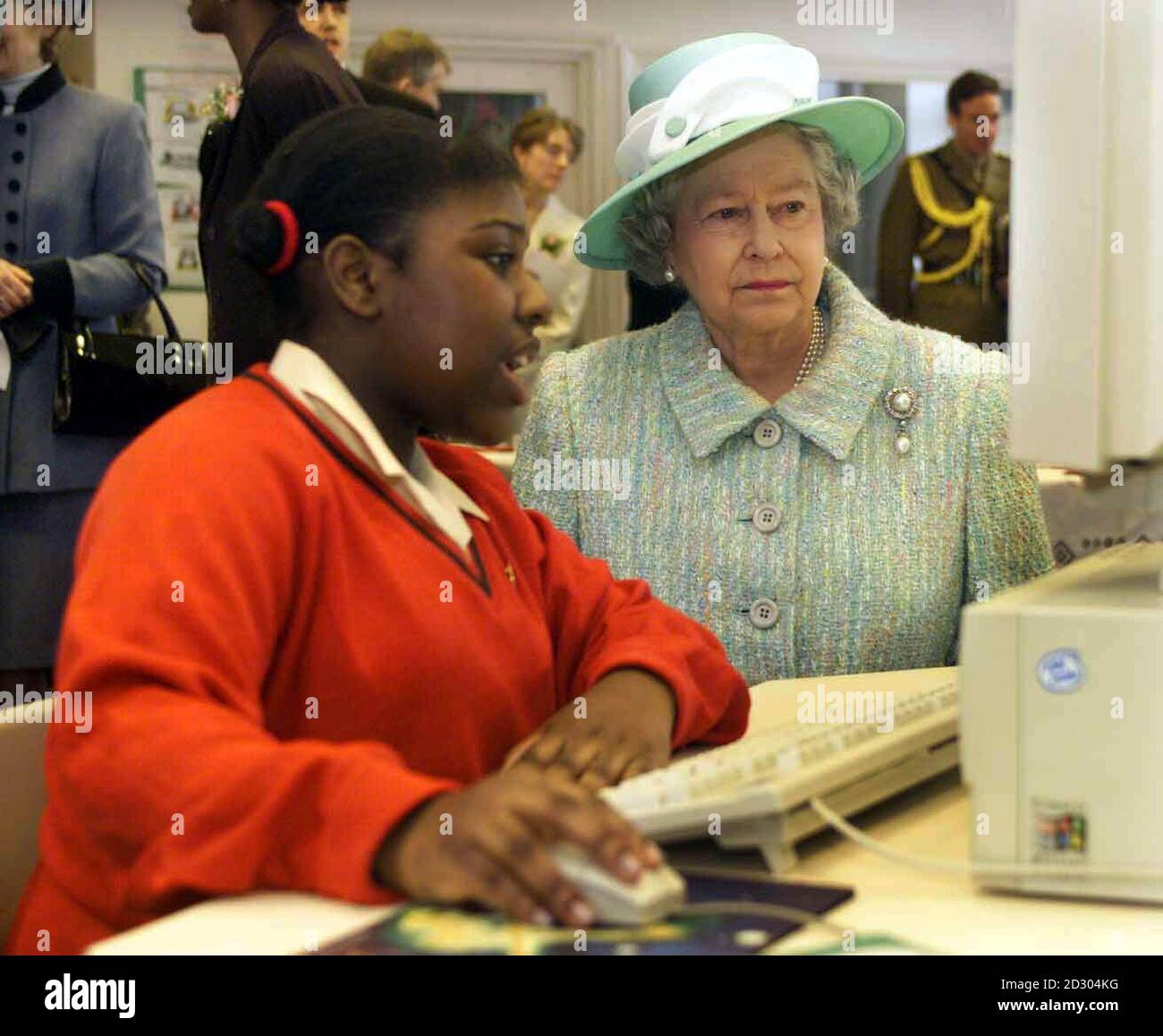 Britain's Queen Elizabeth II watches a pupil having a computer lesson ...