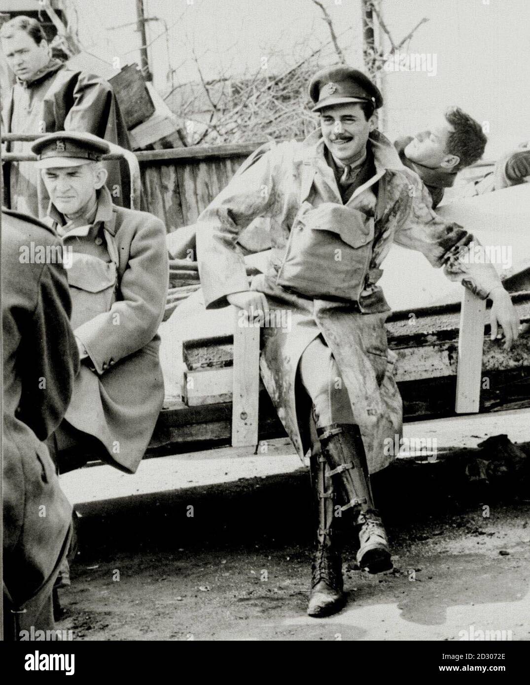 Sir Dirk Bogarde, with trench coat , gas mask case and leggings, during the making of the film ...