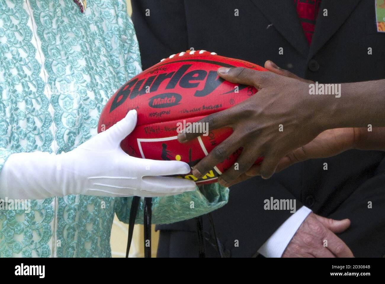 Queen Elizabeth II accepts an Australian Rules football given to her ...