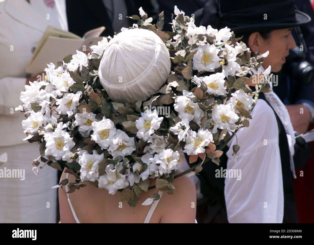 A female race fan wears an intricately designed flower hat, at the ...