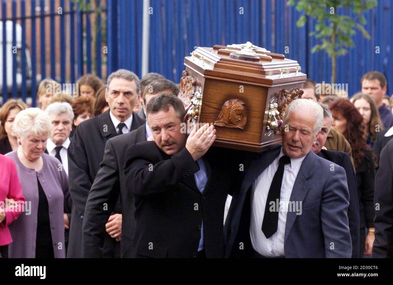 Margaret McKinney (purple Jacket) follows her sons coffin for burial at ...