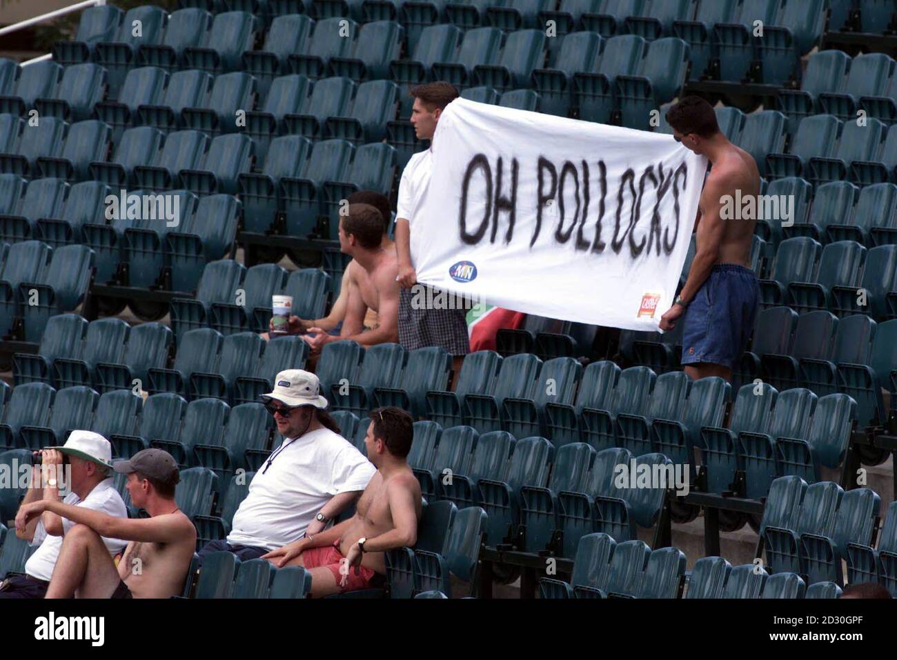 Cricket fans hold up an interesting banner in a virtually empty stand ...
