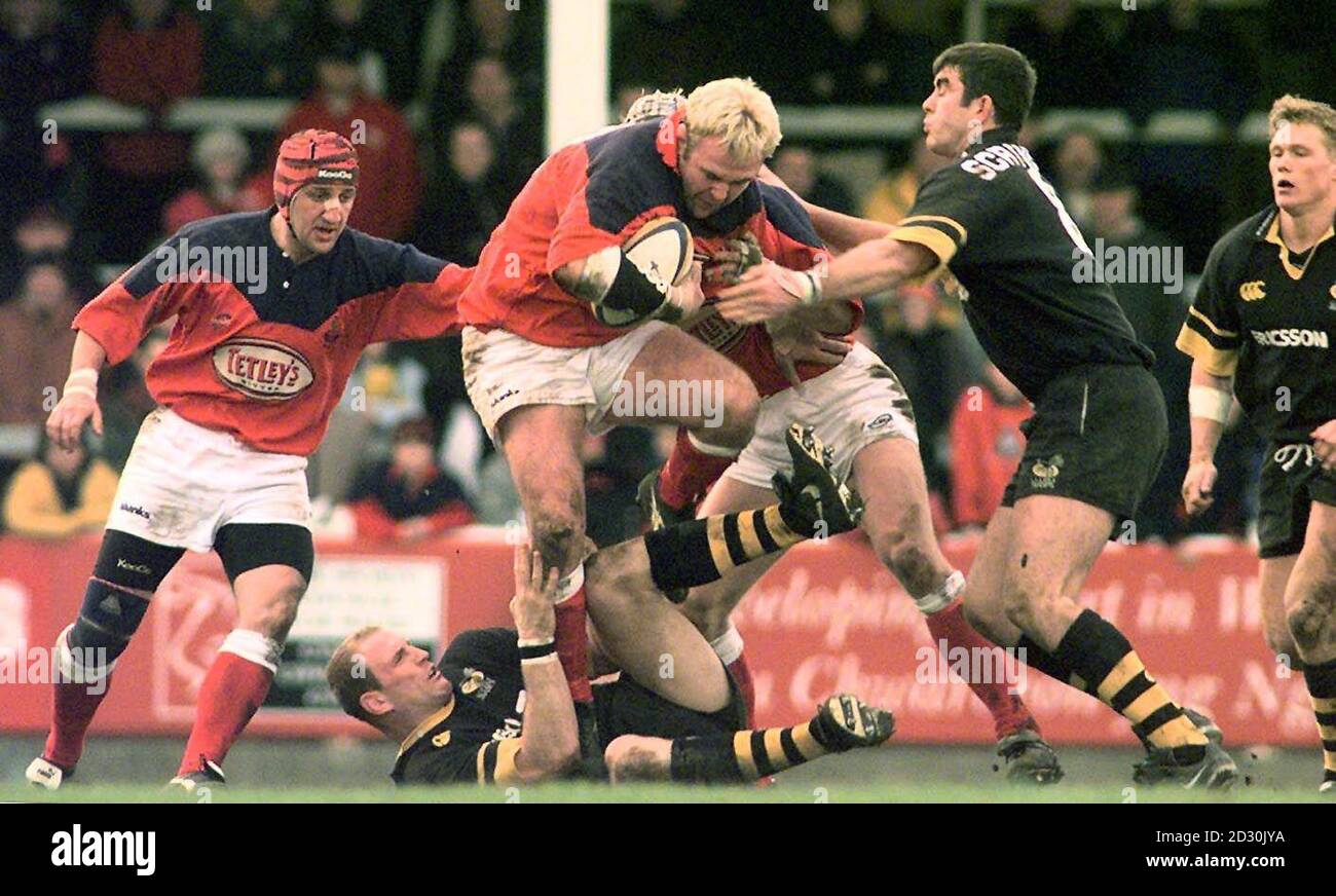 Llanelli's Scott Quinnell (centre, holding ball) hurdles over Wasp's ...