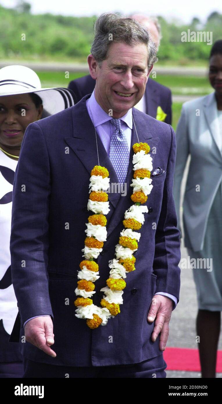 The Prince of Wales wears a flower garland , as he arrives at the ...
