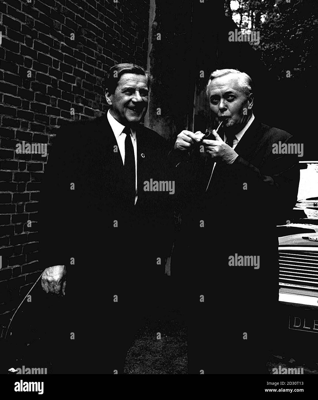Harold Wilson lighting his pipe as he stands with Mr Victor Feather ...