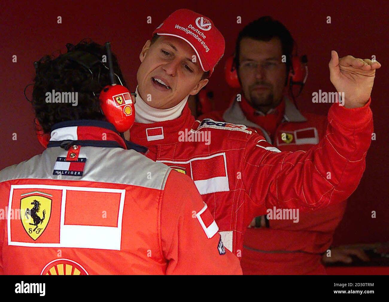 Ferrari driver Michael Schumacher talks to team technicians after the ...