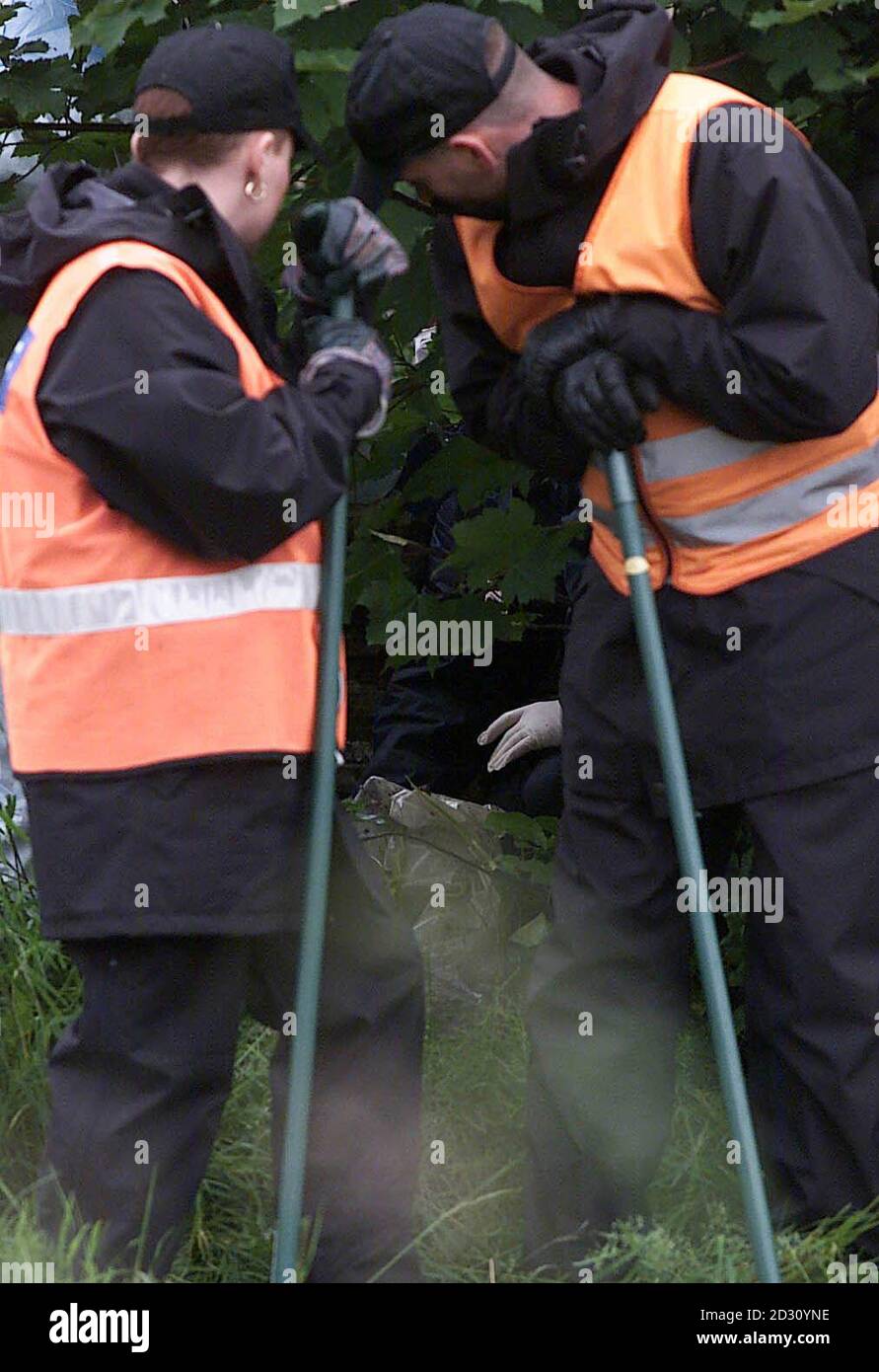 British transport police officers search alongside railway lines near ...