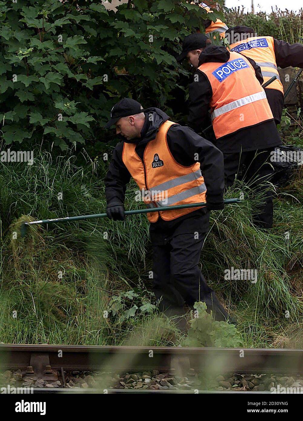 British Transport police officers search alongside railway lines near ...