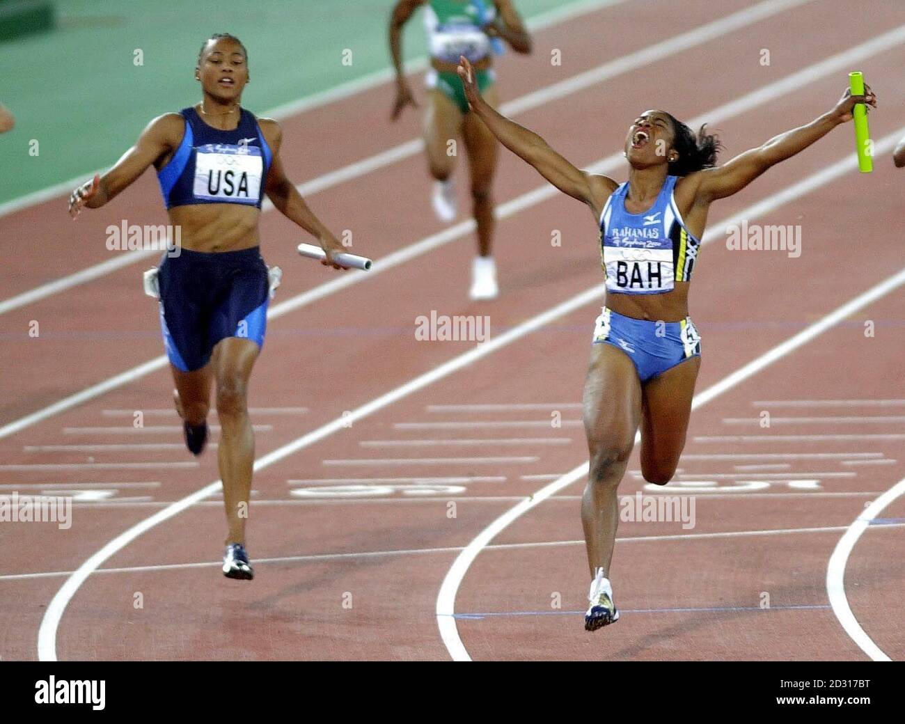 Debbie Ferguson of the Bahamas (right) celebrates as she passes Marion ...
