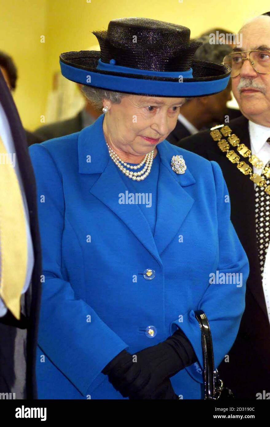 The Queen watches a display of plastering, during a visit to the ...