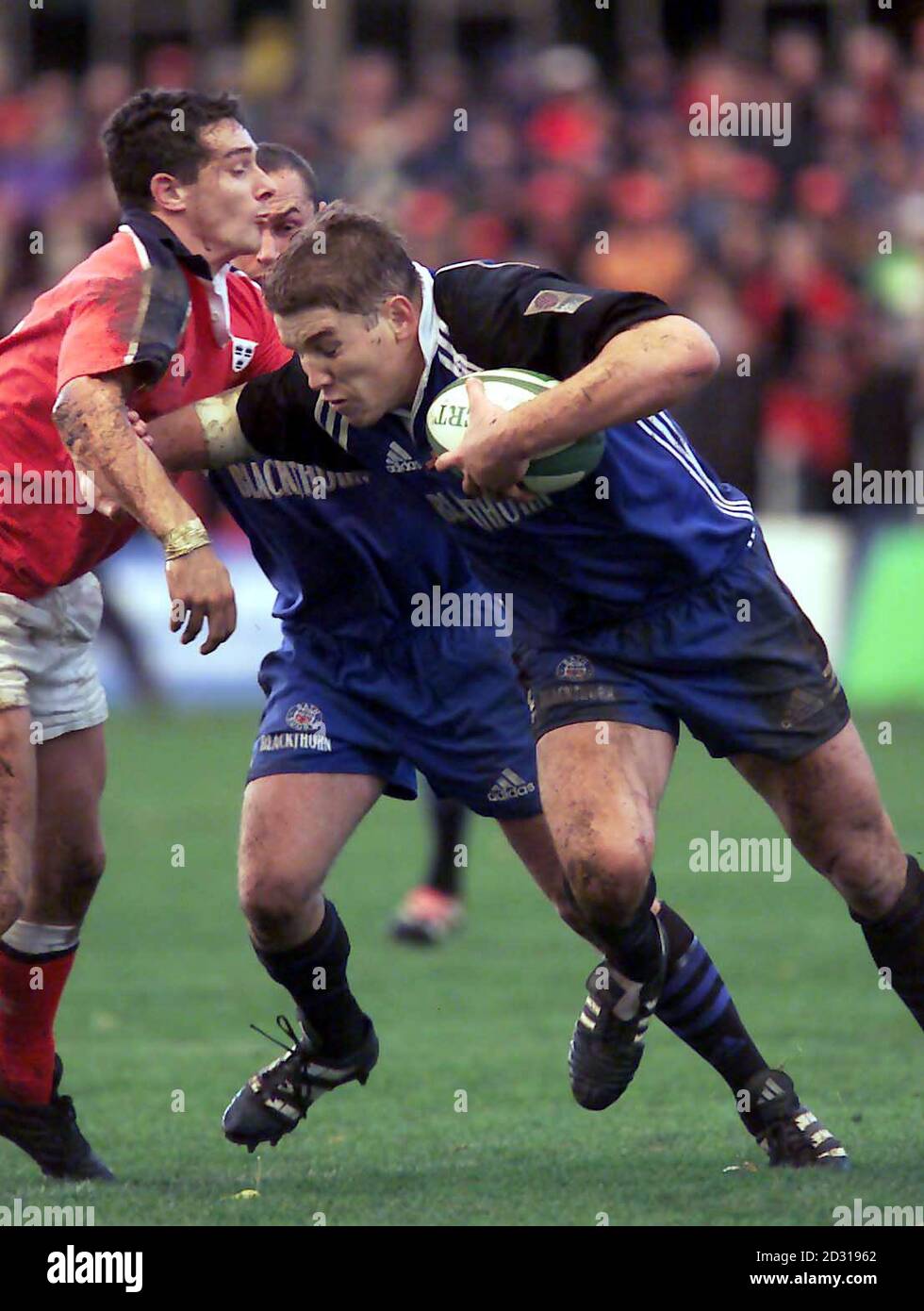 Dan Lyle of Bath (blue and black) charges at Munster's Jason Holland at ...