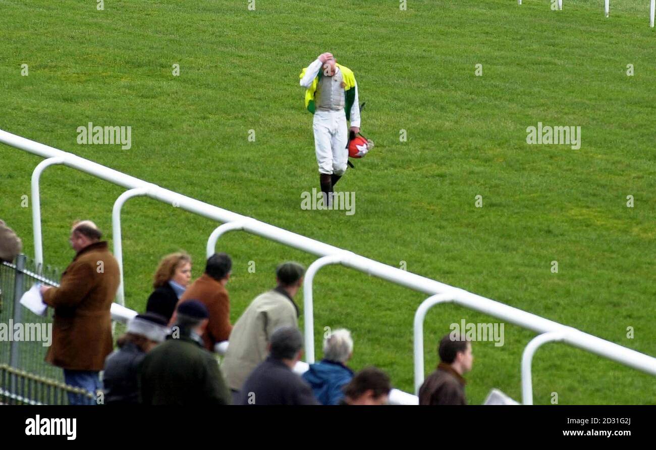 Jockey Russ Garritty walks back after his horse Young Kenny suffered a ...