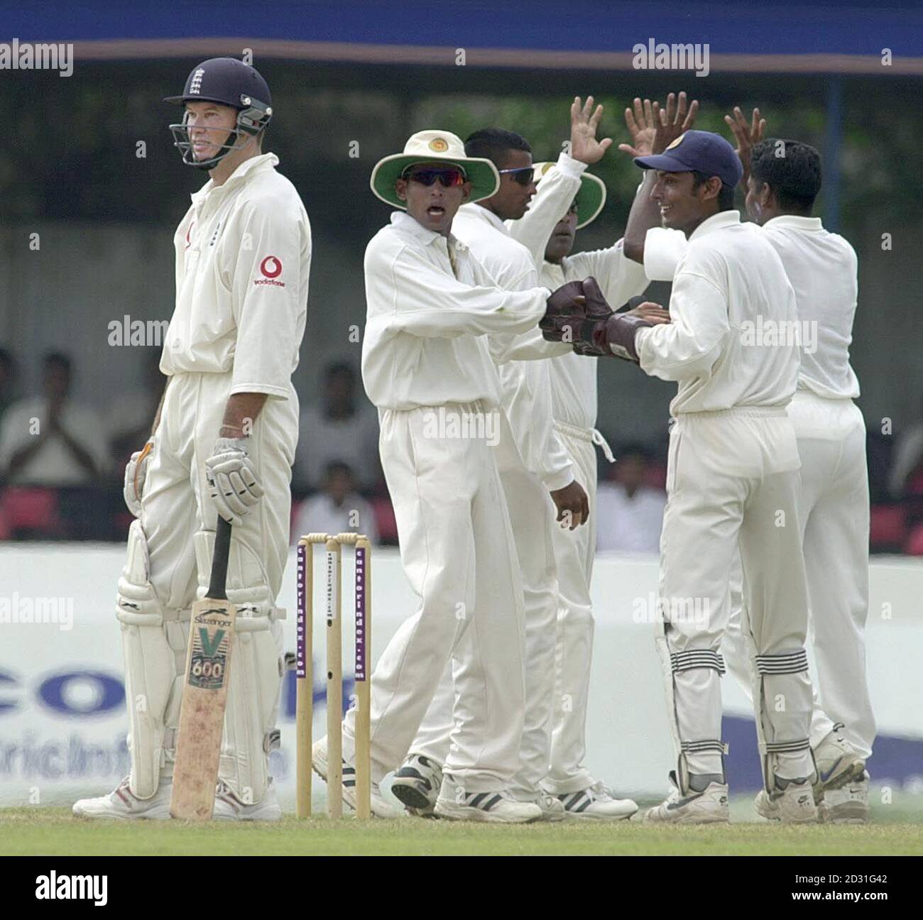 England's Graeme Hick stands at the crease as the Sri Lankans celebrate ...