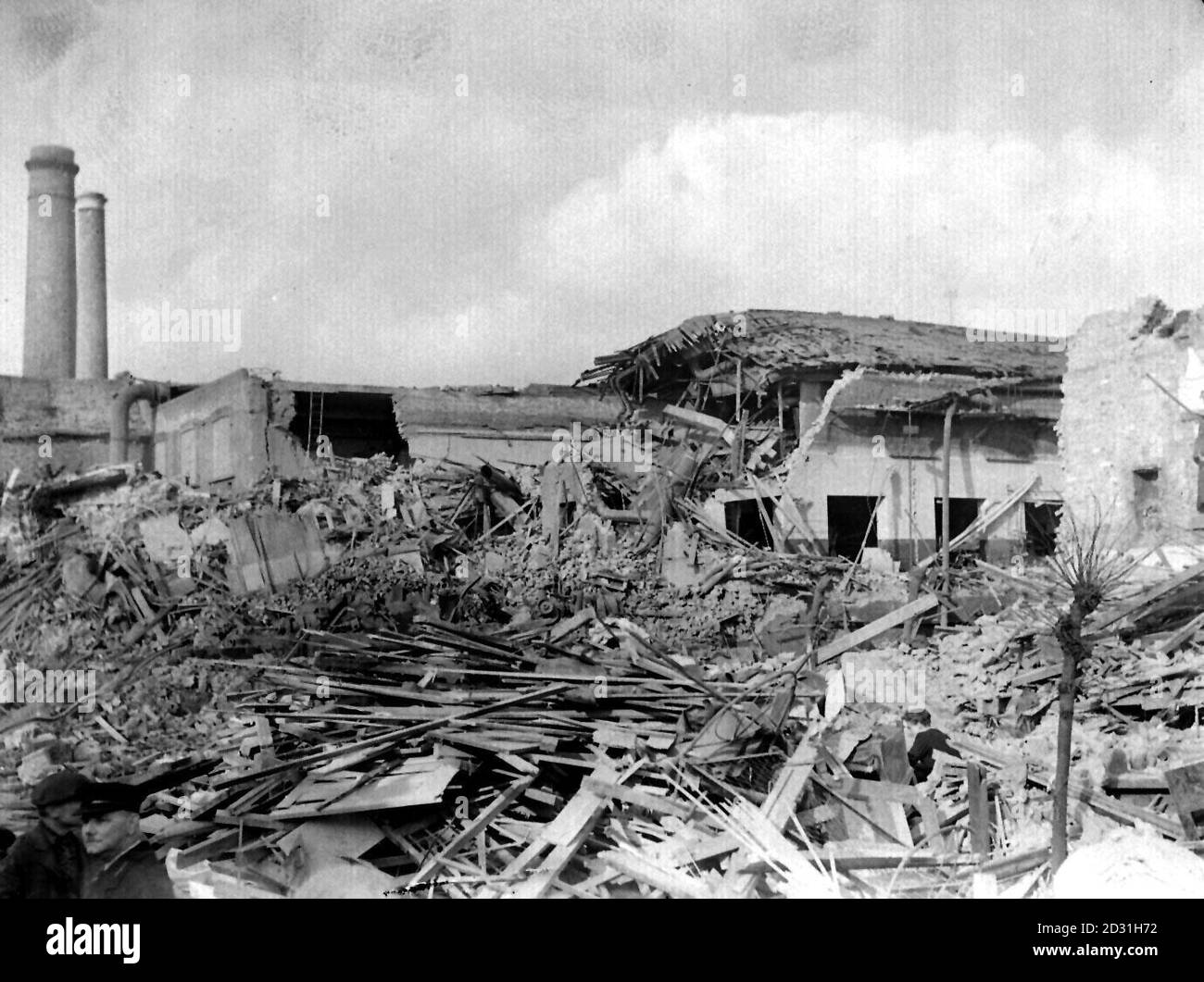 c1945: Rescue workers inspect the damage caused by the explosion of a ...