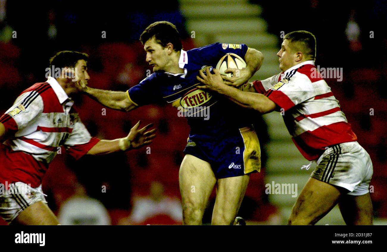 Wigan's Harvey Howard (left) and Terry Newton try to stop Leeds's Brett ...