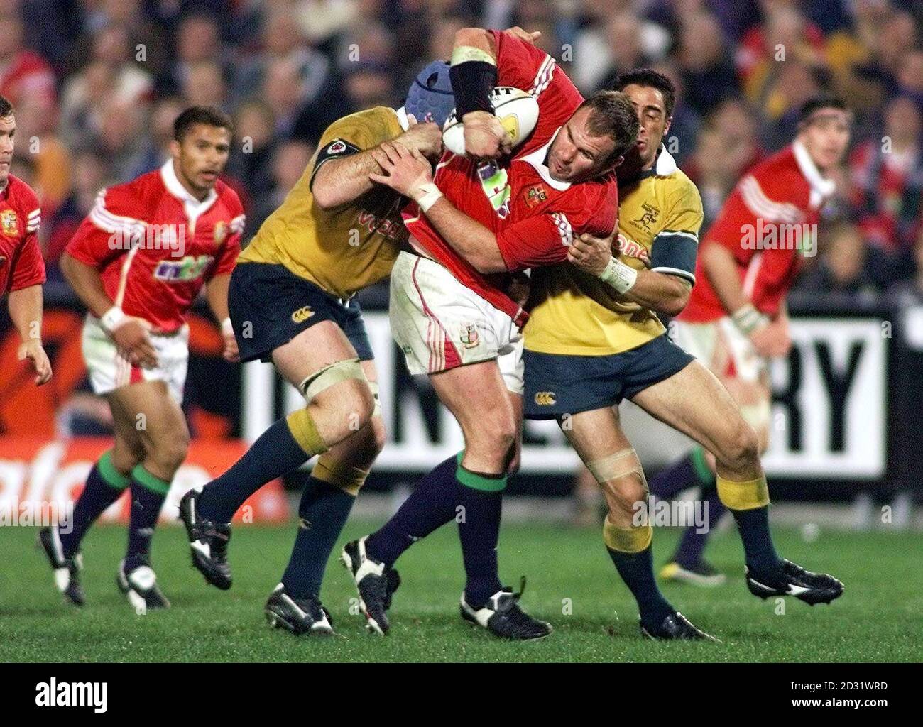 British Lions' Scott Quinell (centre) surges through the challenge of ...