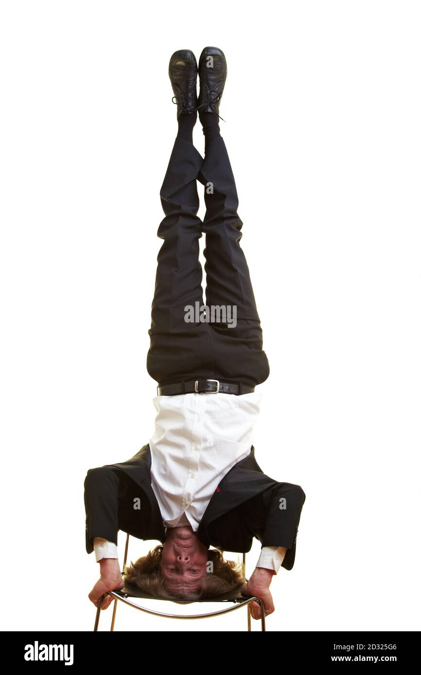 Manager does a headstand on a chair Stock Photo - Alamy