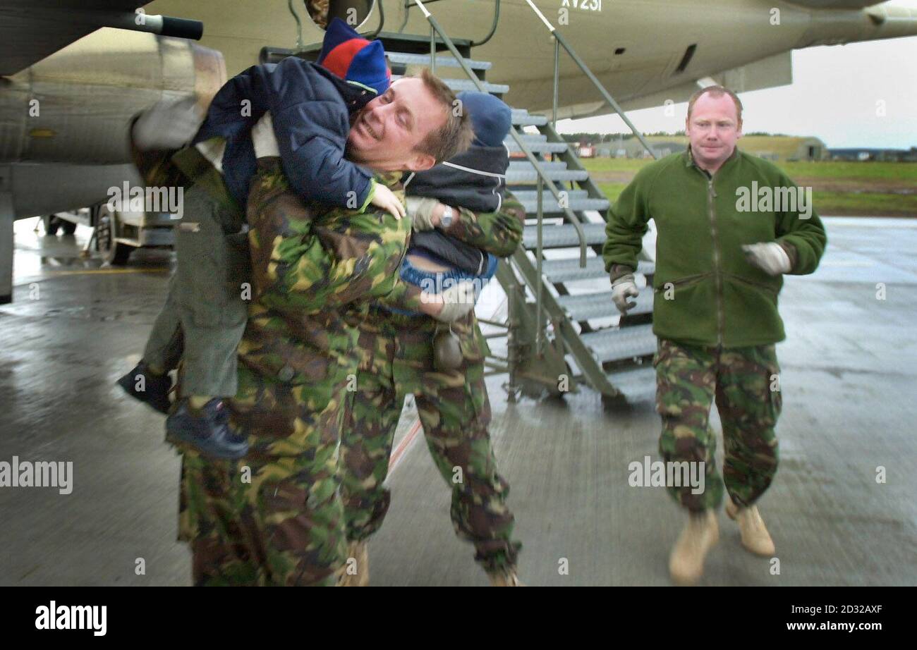 A crew-member hugs his child as he returns to RAF Kinloss in Scotland ...