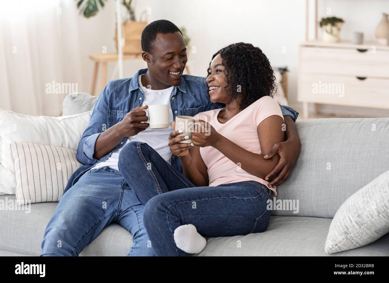 Young black man and woman enjoying weekend at home together Stock Photo ...