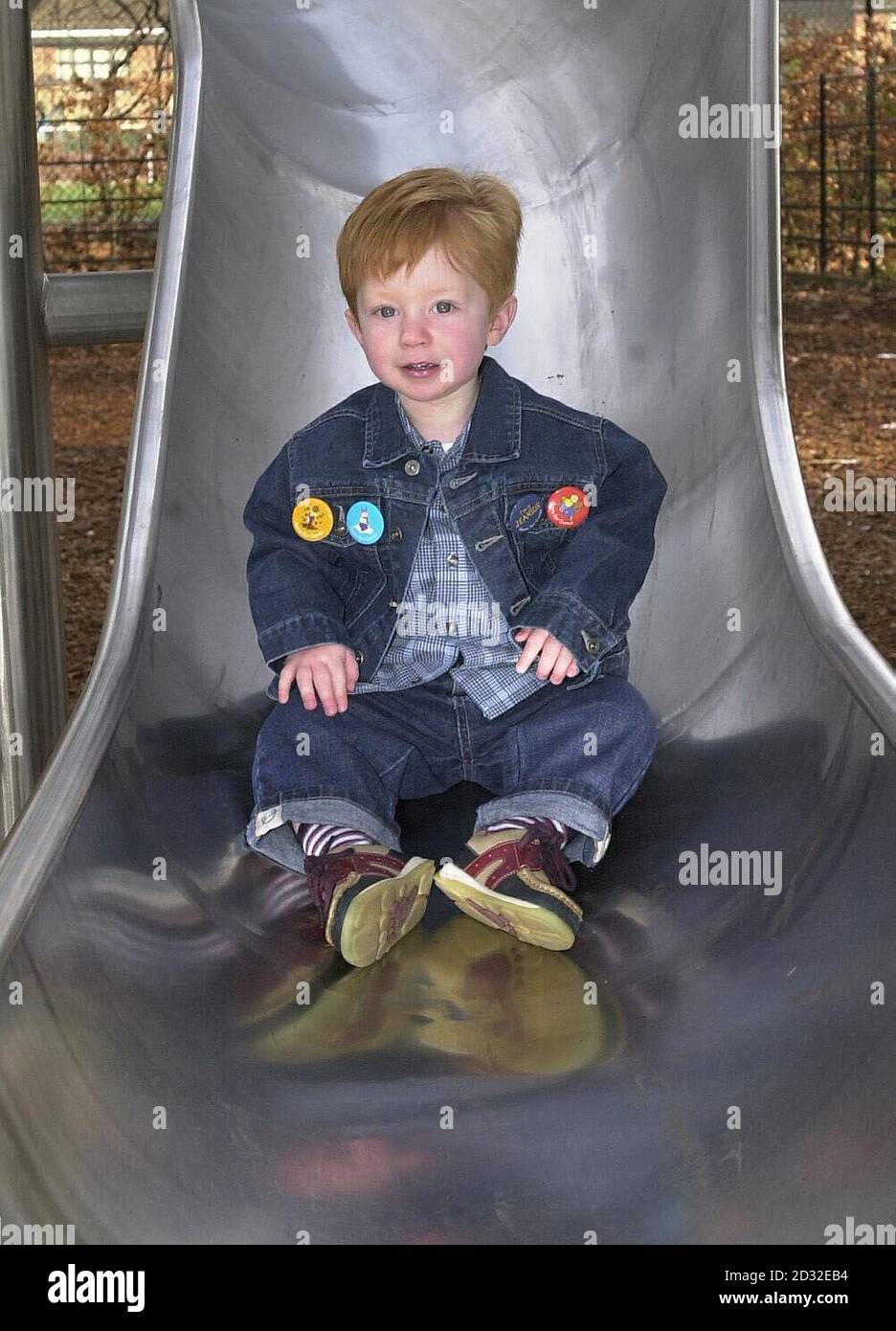Rhys Evans, born 18 months ago in South Wales, plays on a slide in ...