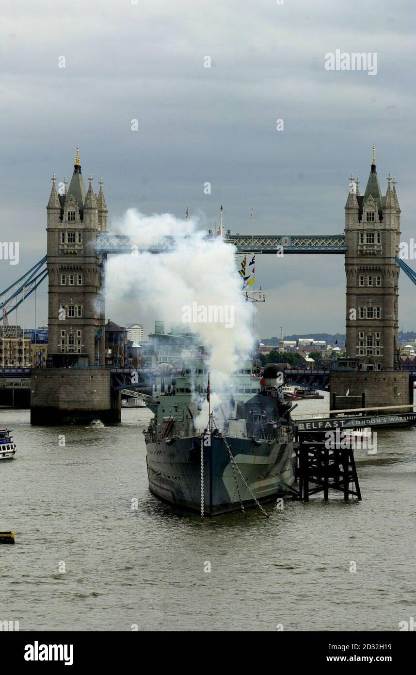 HMS Belfast, moored between London Bridge and Tower Bridge, fires a ...