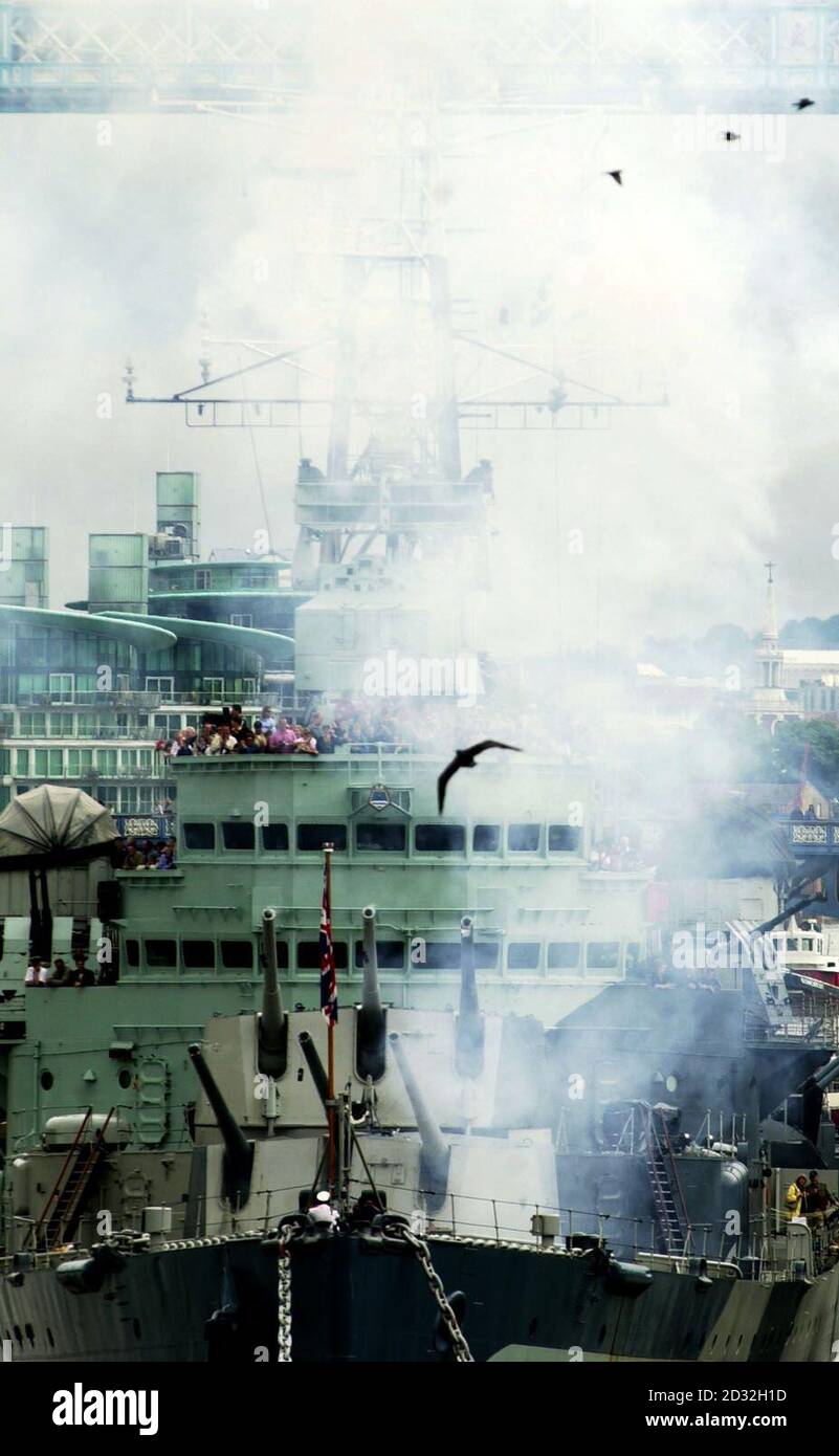 HMS Belfast, moored between London Bridge and Tower Bridge, fires a ...