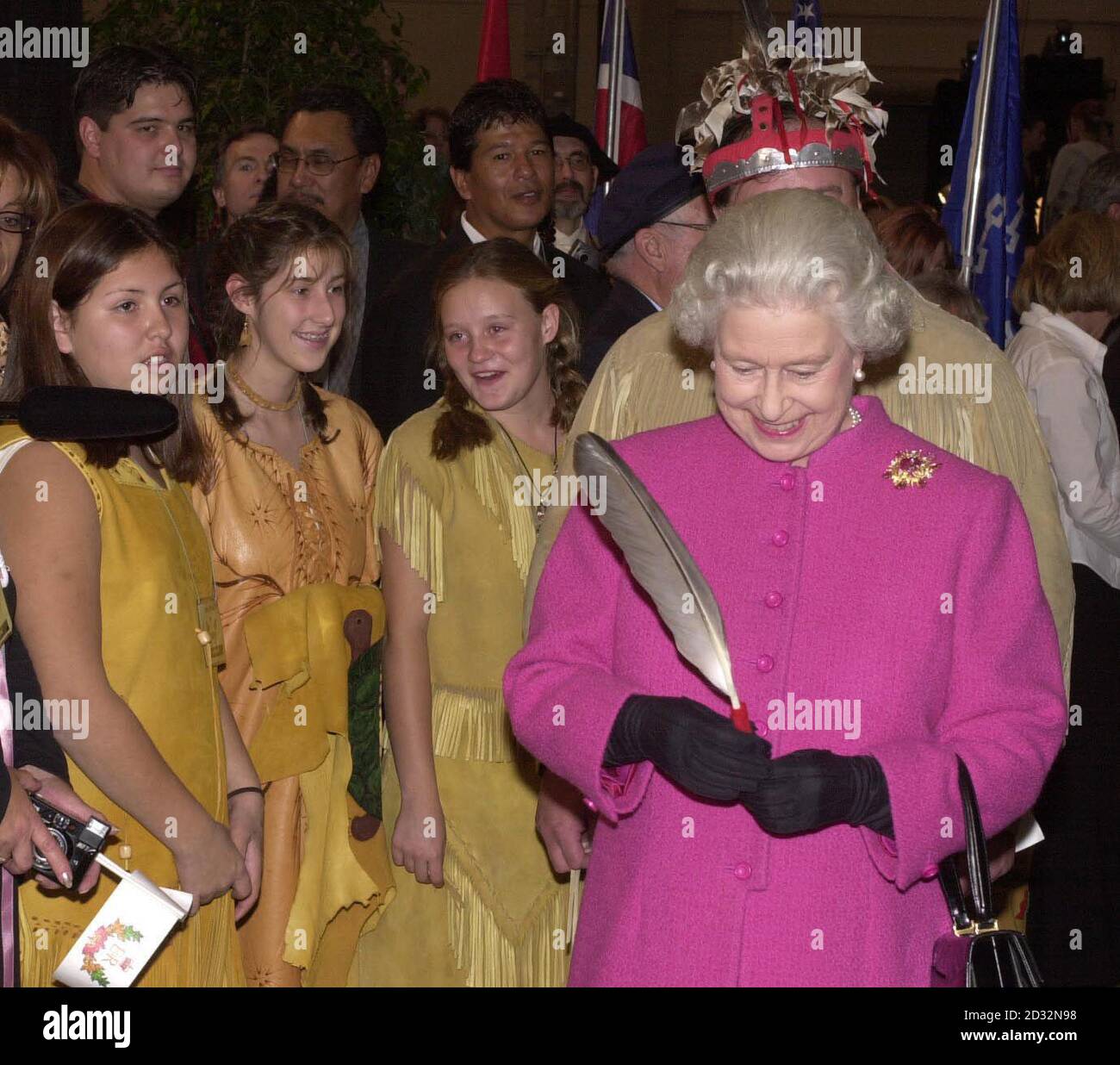 Queen Elizabeth II holds a feather given to her by a group of First ...