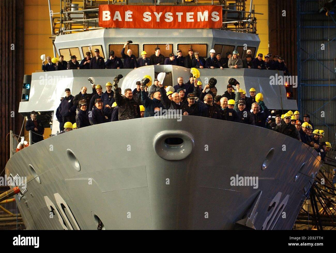 Workers gather on a 95-metre warship at BAE Systems' dry dock ...