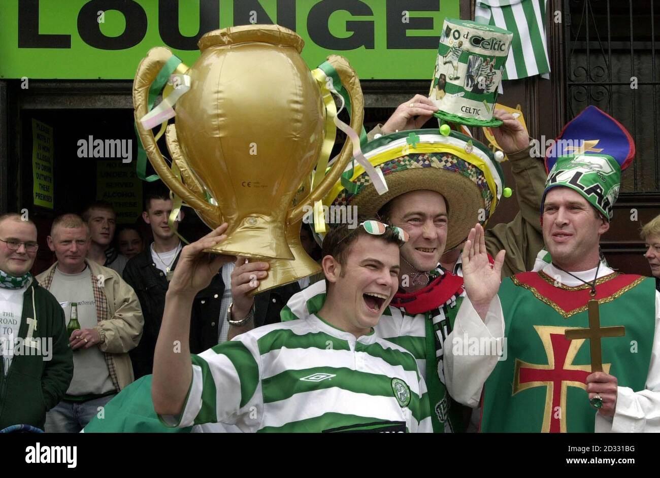 Celtic fans, one dressed as the Pope (right), gather outside a pub in ...