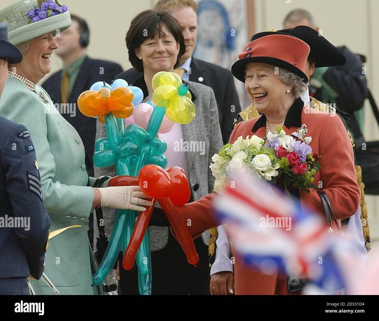 Britain's Queen Elizabeth II hands over a bunch of balloons given to ...