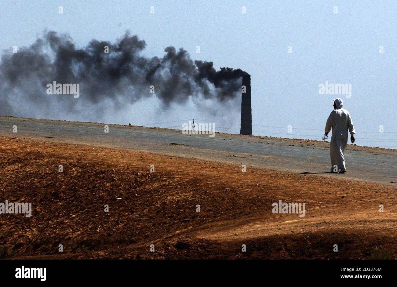 An Iraqi walks to work in factory near the Tigres river outside Al ...