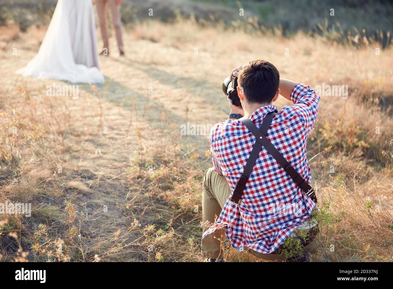 wedding professional photographer takes pictures of the bride and groom ...