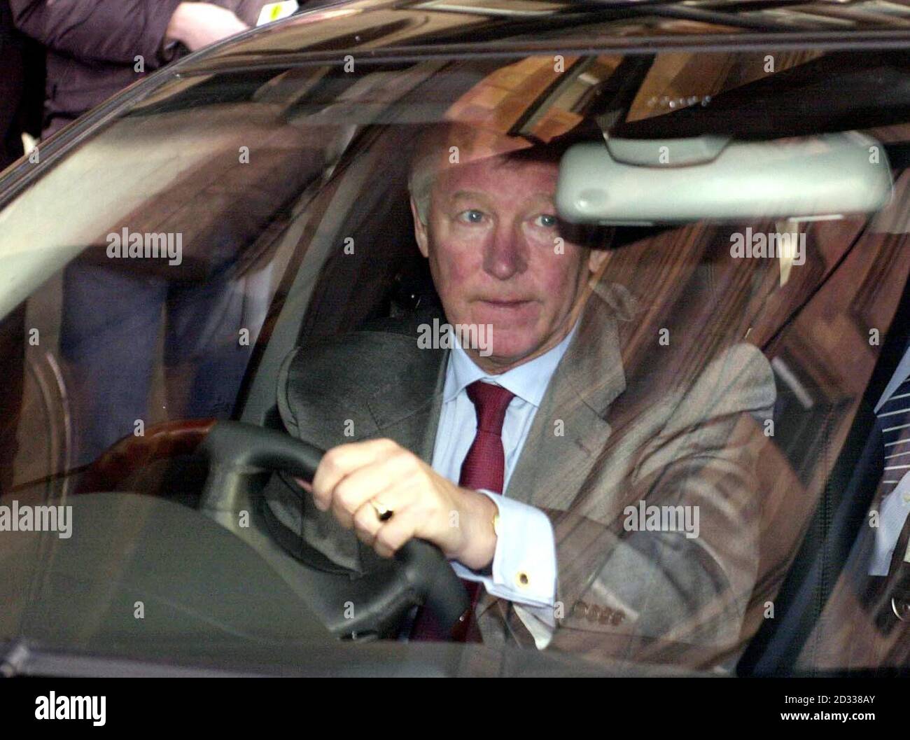Manchester United manager Sir Alex Ferguson leaves in his car from the ...