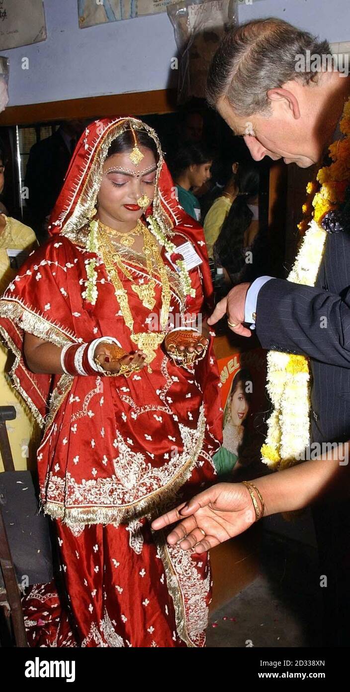 The Prince of Wales studies the artwork on the hands of Manorama Singh ...