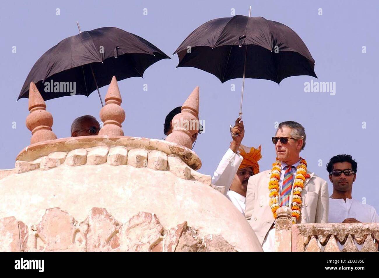 The Prince of Wales, is shaded from the sun during his visit to the ...