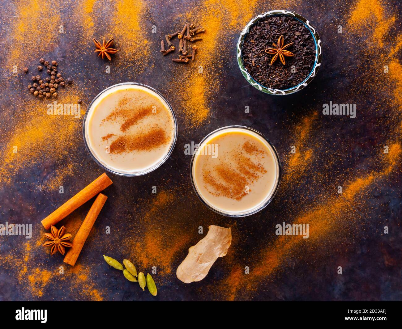 Masala chai tea on a black background. Two transparent glasses of ...