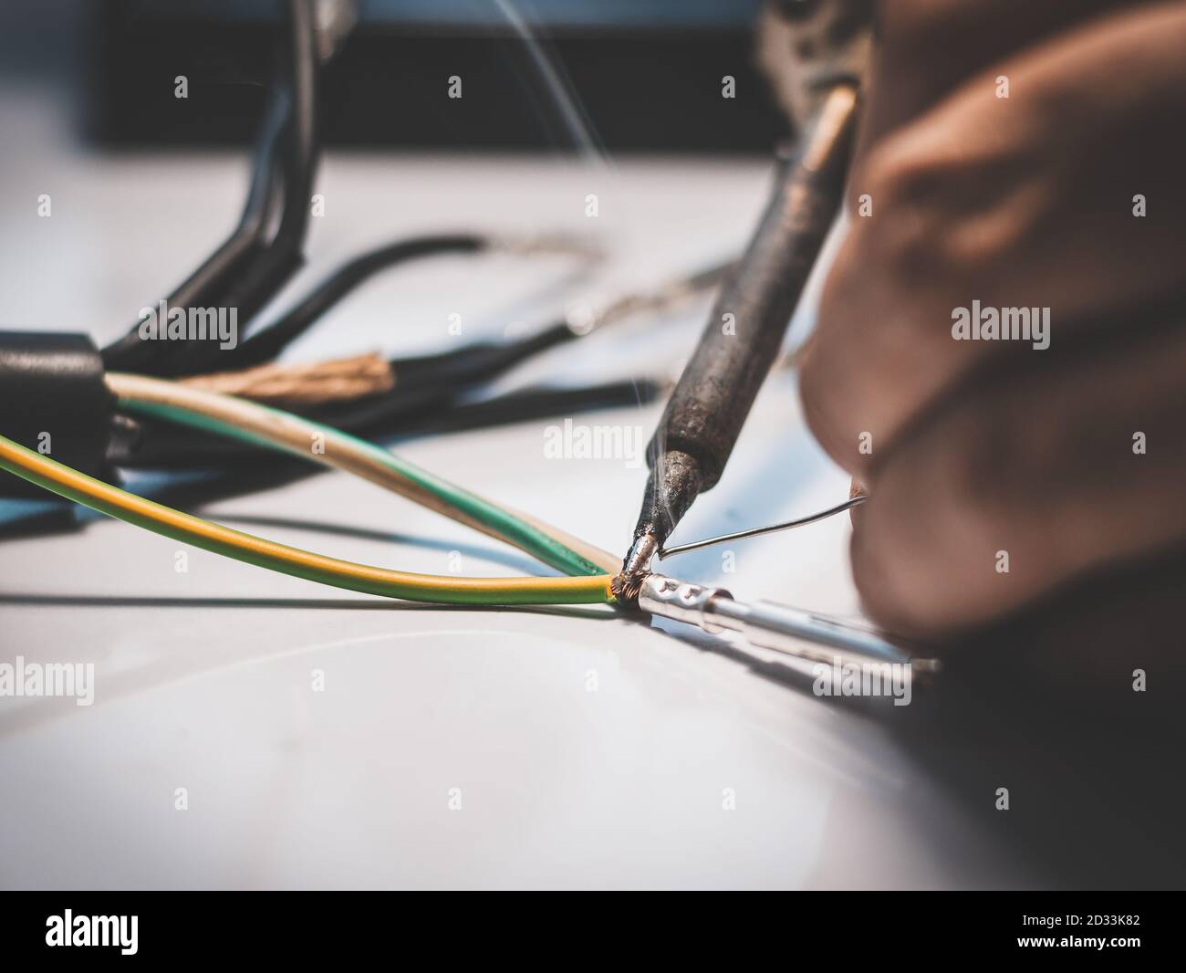 Electricians are using a soldering iron to connect the wires to the ...