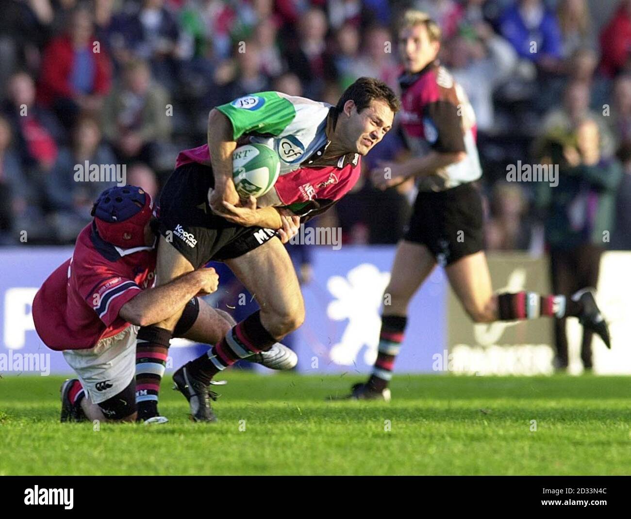 Munster's Mike Mullins (left) tackles Harlequins' Matt Moore during the ...