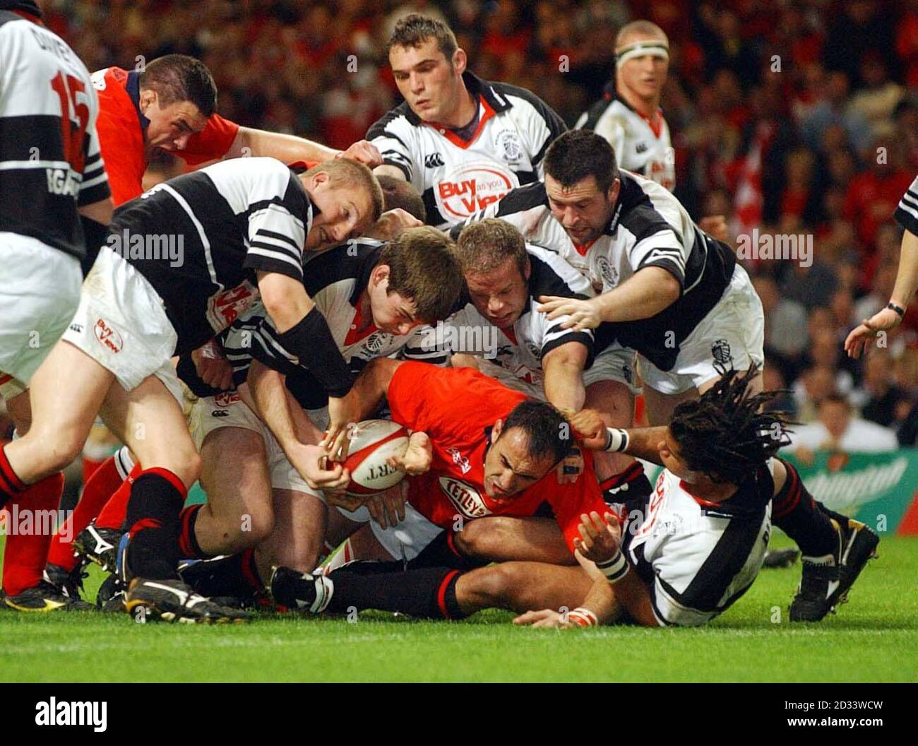 Llanelli's Chris Wyatt (centre, red) is brought down by the Pontypridd ...