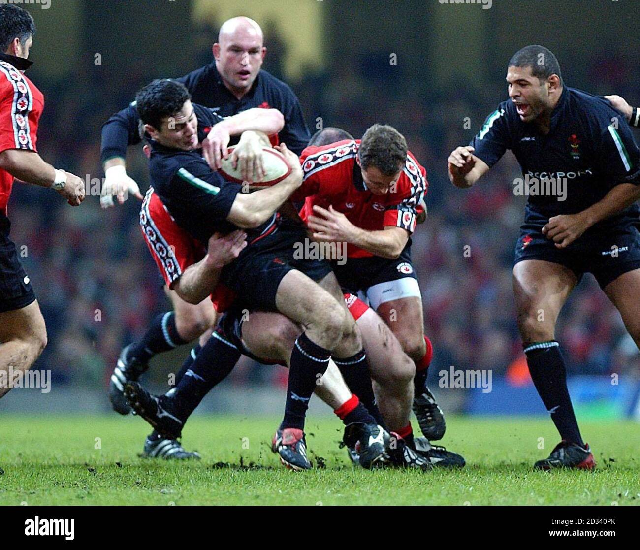 Wales' Stephen Jones (centre left) is tackled by the Canadian defence ...