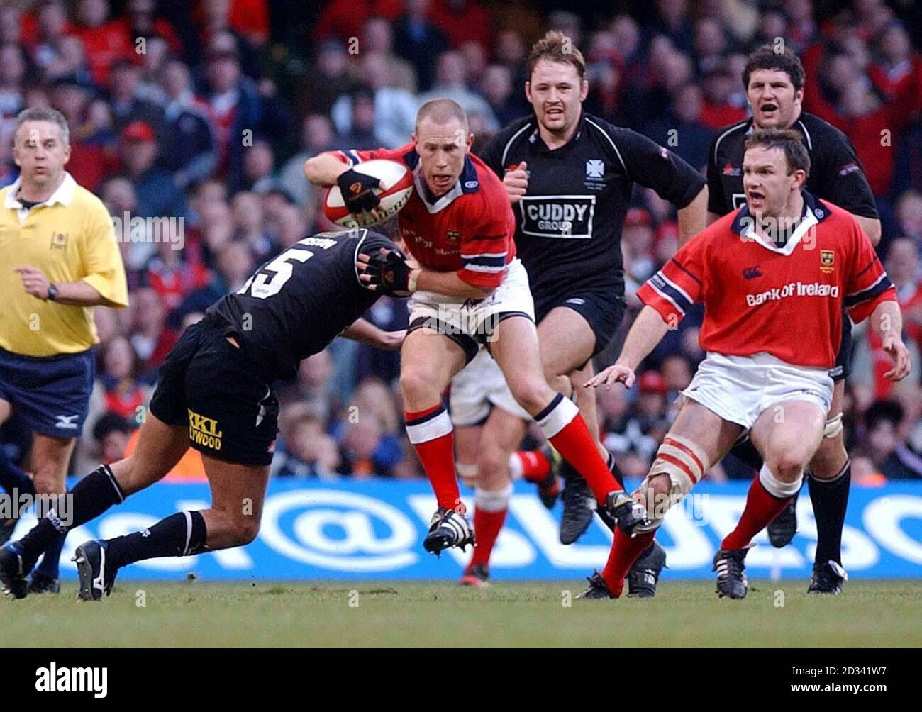 Munster's Peter Stringer hops out of a tackle by Neath's Adrian Durston ...