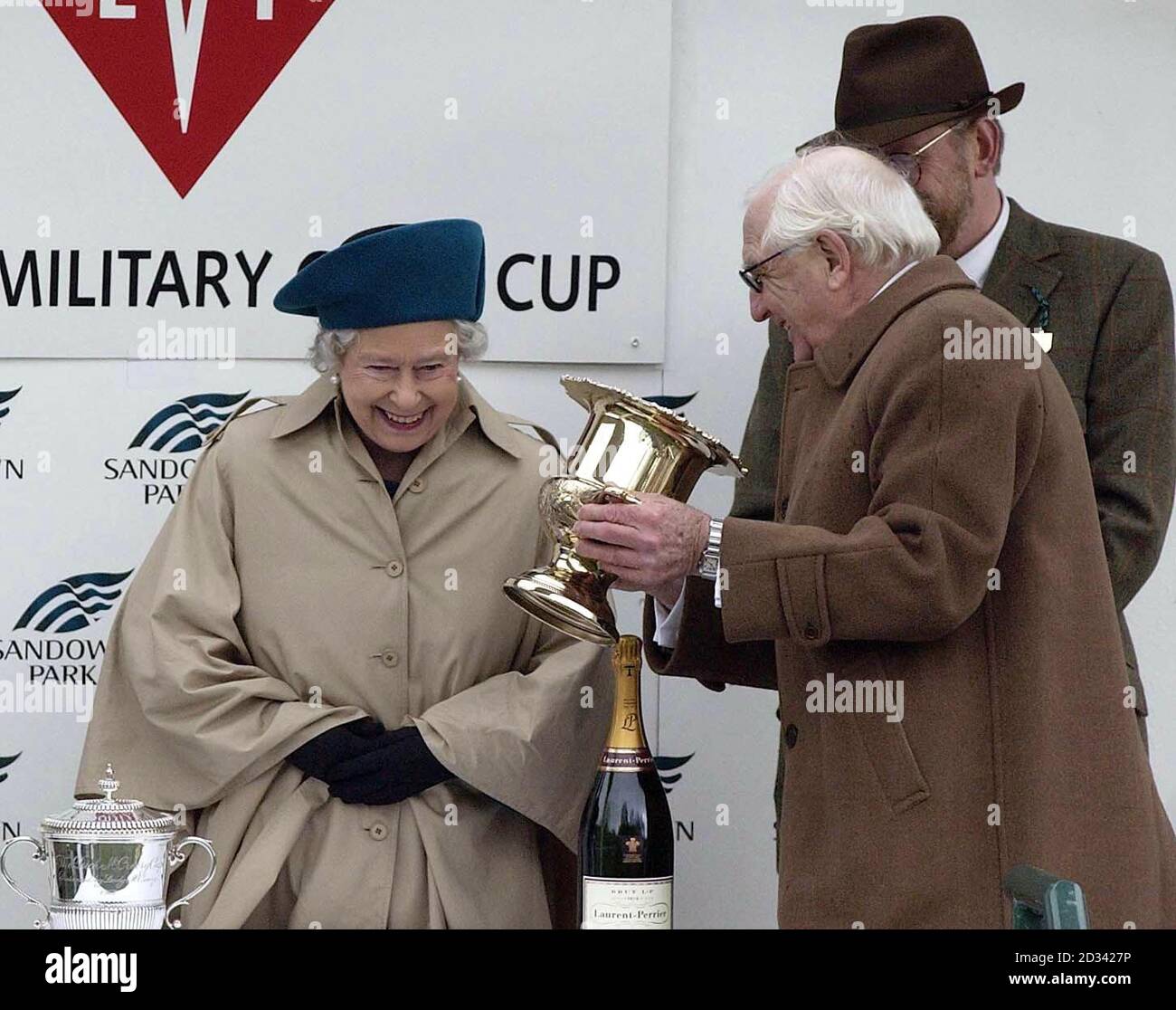 Britain's Queen Elizabeth II presents the winners trophy to owner Ron ...