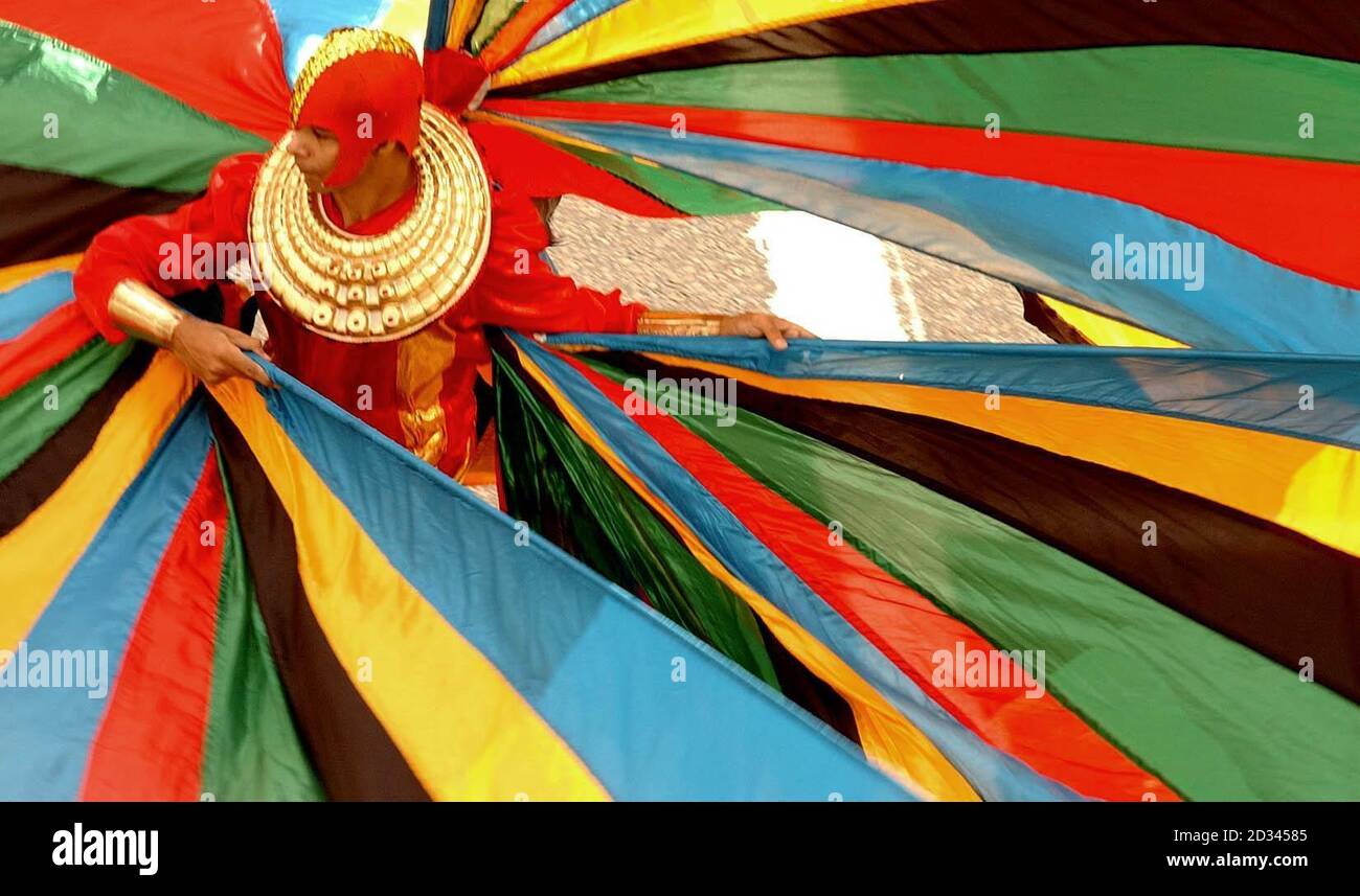 A dancer wearing the Olympic colours twirls ahead of the floats during ...