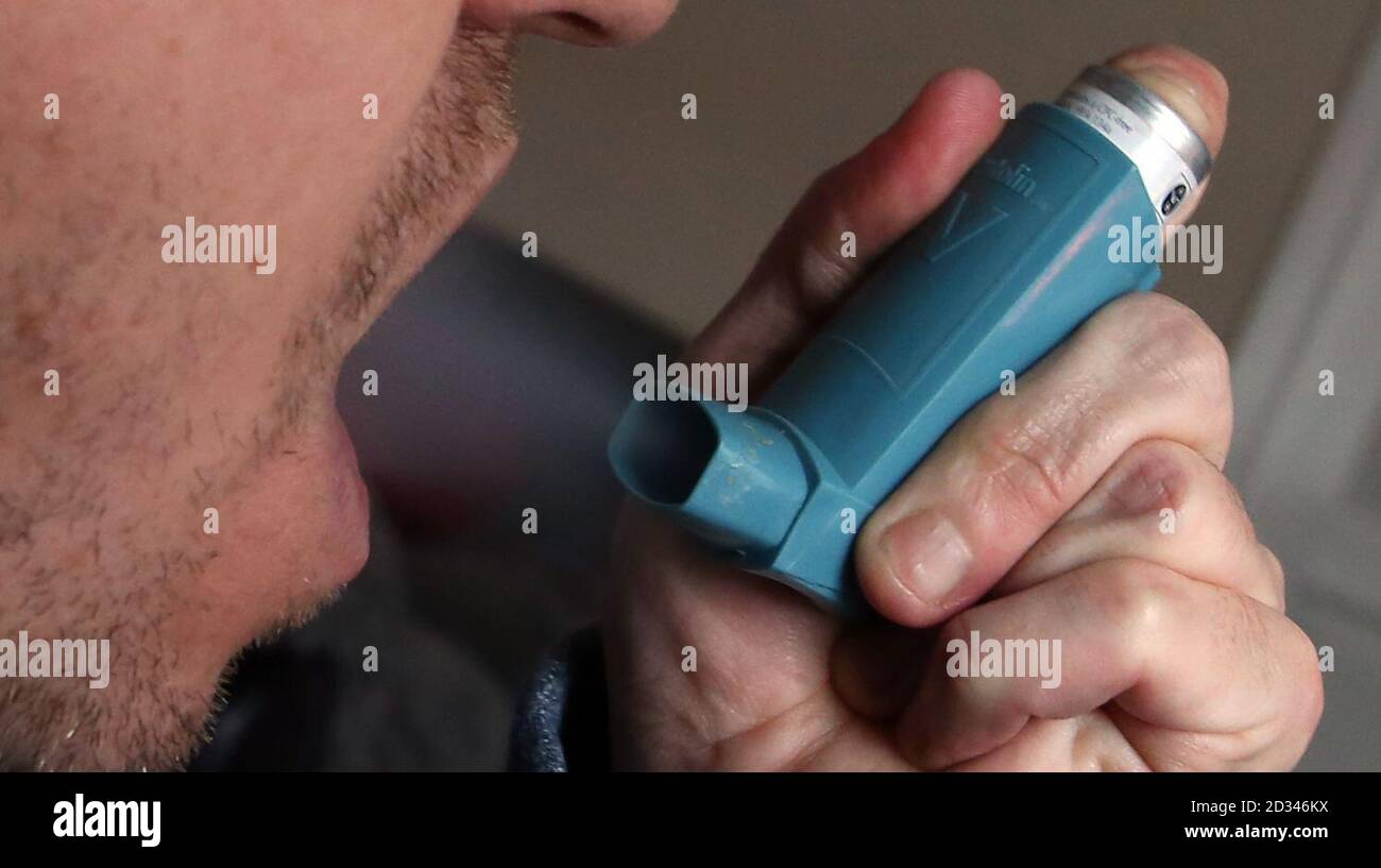 A person using an inhaler for the treatment of asthma Stock Photo - Alamy