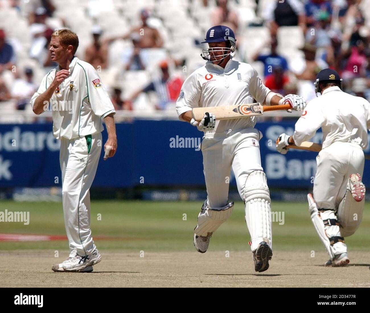 South Africa's Shaun Pollock (L) watches as England's Ashley Giles (C ...