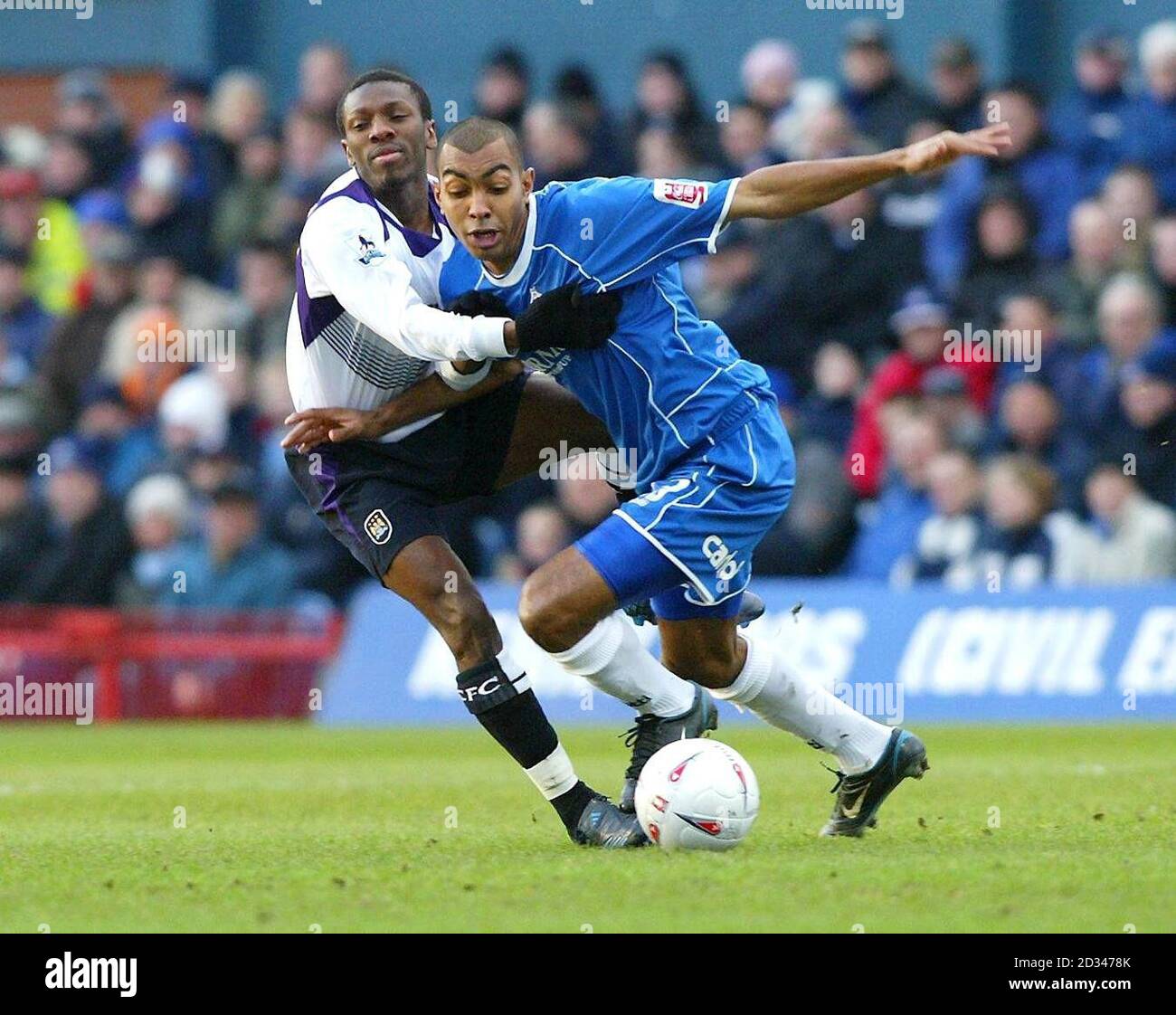 Oldham Athletic's Kevin Betsy (right) is challenged by Manchester City ...