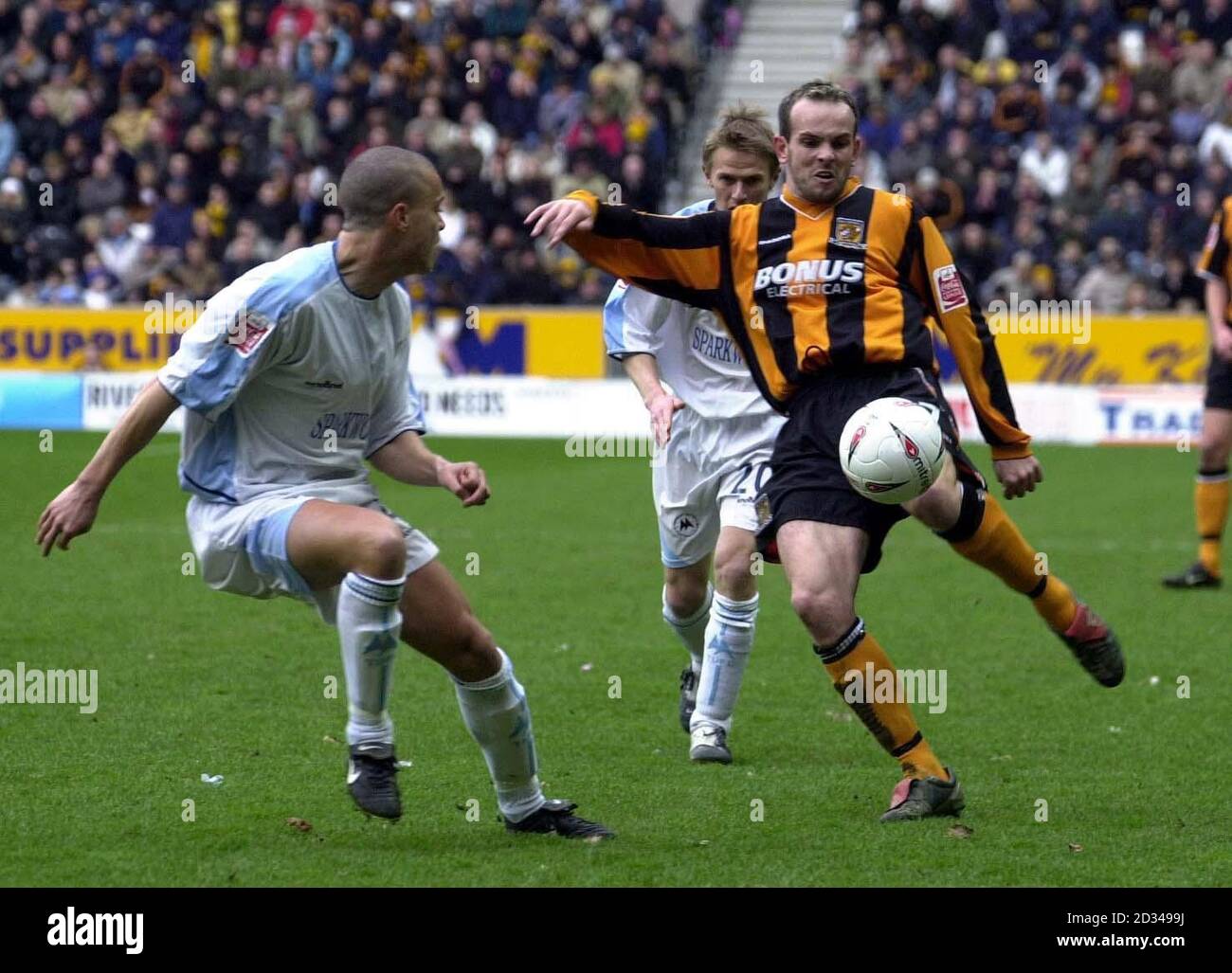 Hull's Stuart Elliott (R) gets in his cross despite pressure from ...