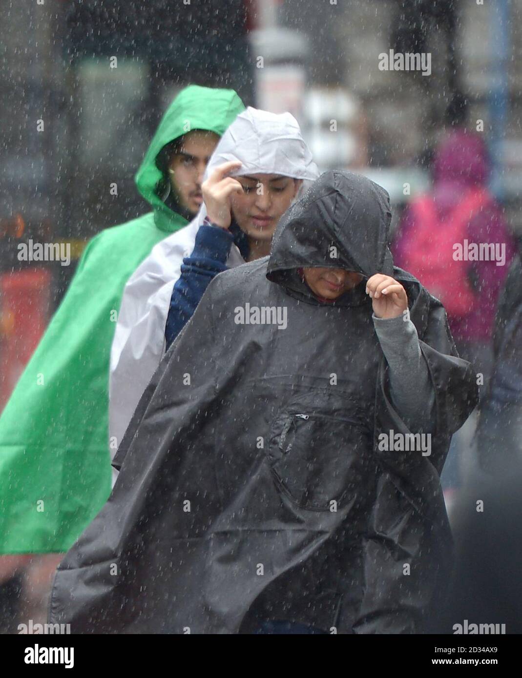 Members of the public get caught in heavy rain in central London Stock ...